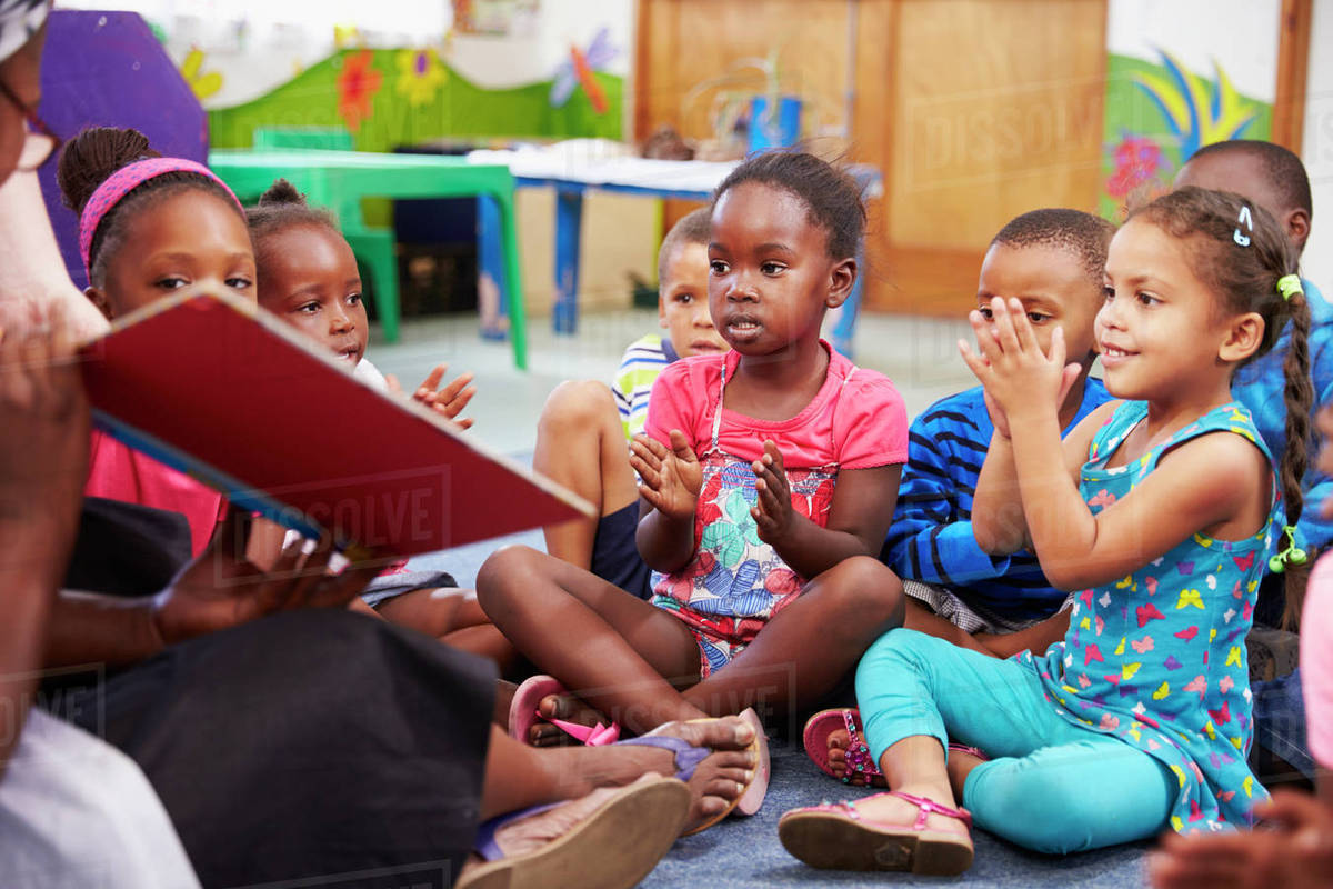 Teacher reading a book with a class of preschool children - Royalty ...