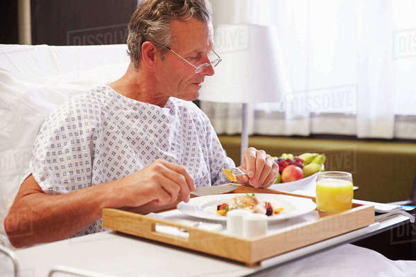 Male Patient In Hospital Bed Eating Meal From Tray - Royalty-free Stock ...