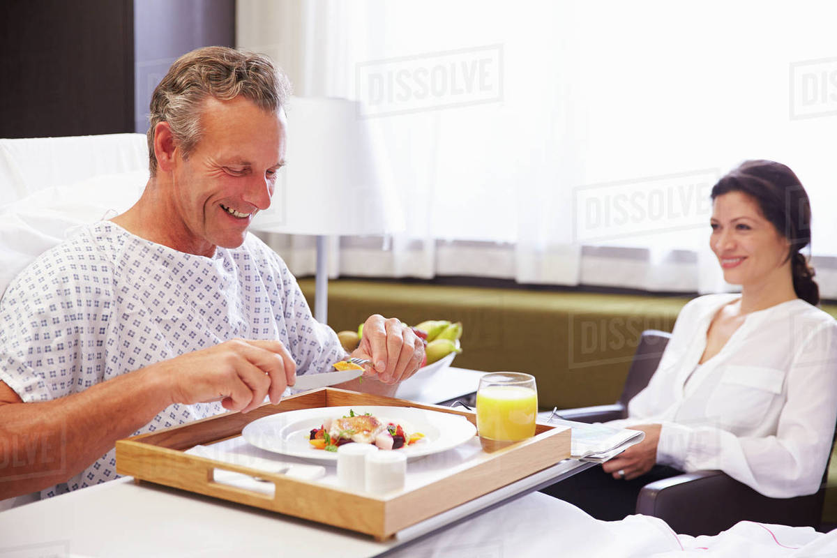 Male Patient In Hospital Bed Eating Meal From Tray - Royalty-free Stock ...