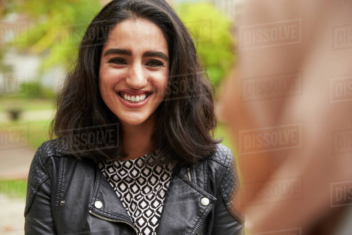 Two british muslim women meeting in urban park - Stock Photo - Dissolve
