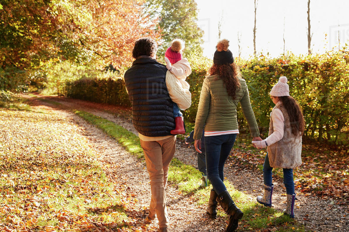 Rear view of family enjoying autumn walk in countryside - Royalty-free ...