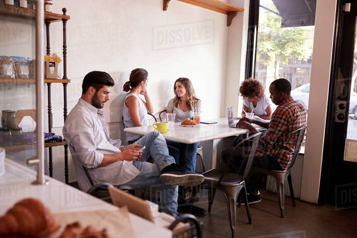 Five young adults hanging out at a coffee shop - Royalty-free Stock ...