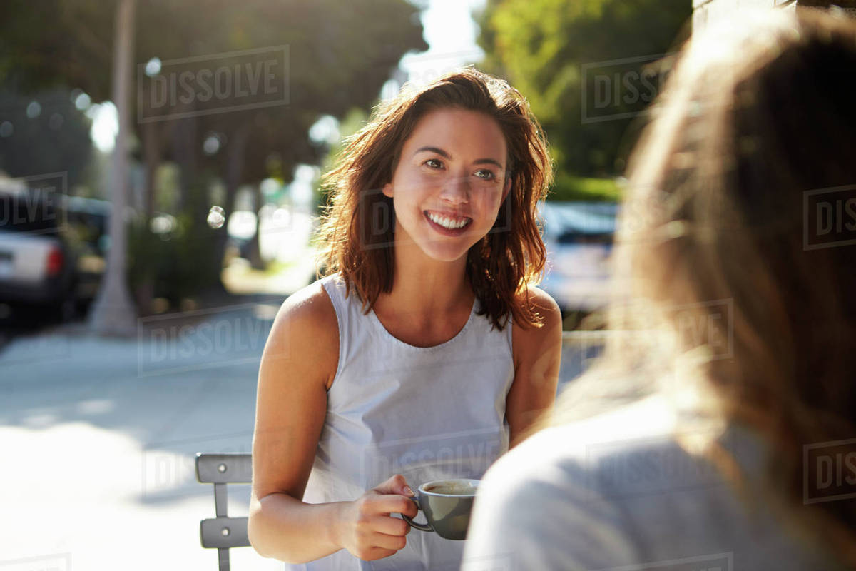 Two female friends talking over coffee outside a cafe - Stock Photo ...