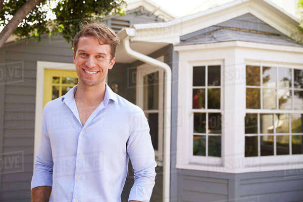 Portrait of excited couple standing outside new home - Royalty-free ...
