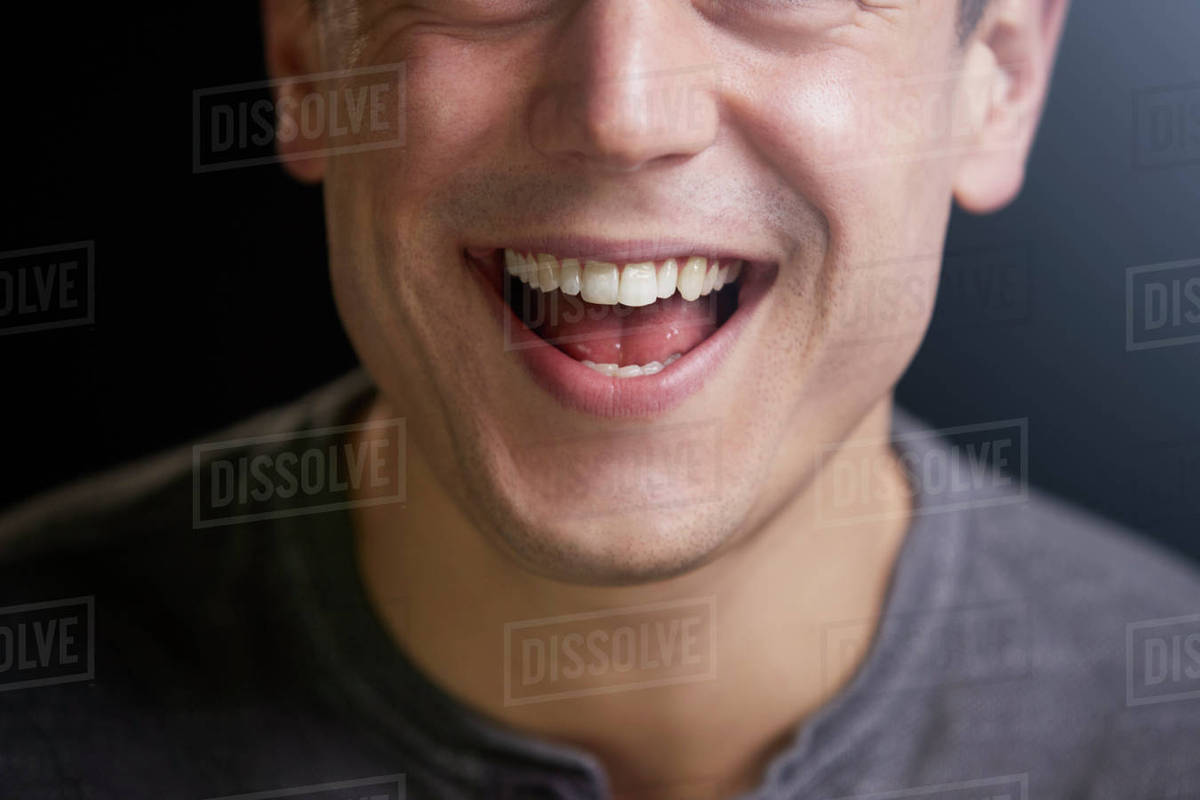 Cropped portrait of a laughing young white man - Stock Photo - Dissolve