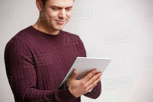 Smiling young white man using a tablet computer - Royalty-free Stock ...