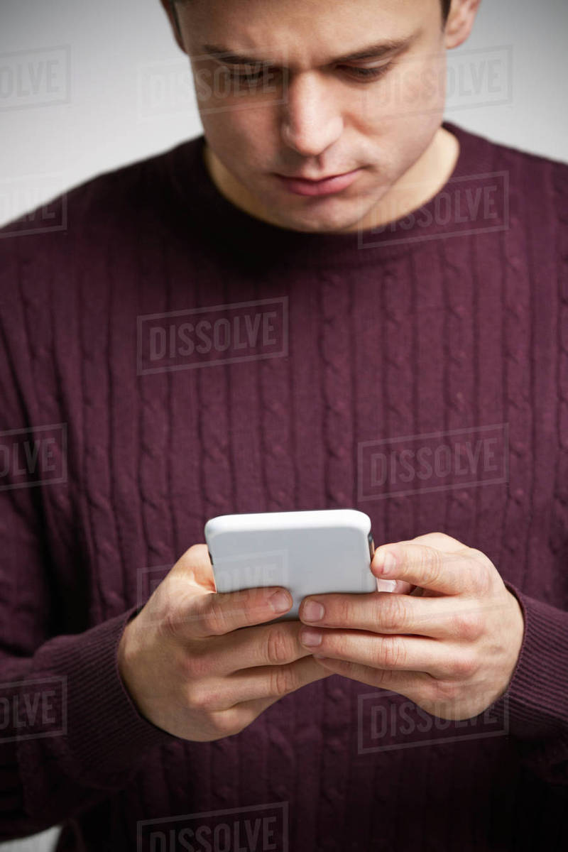 Vertical portrait of a young white man using a smartphone - Royalty ...