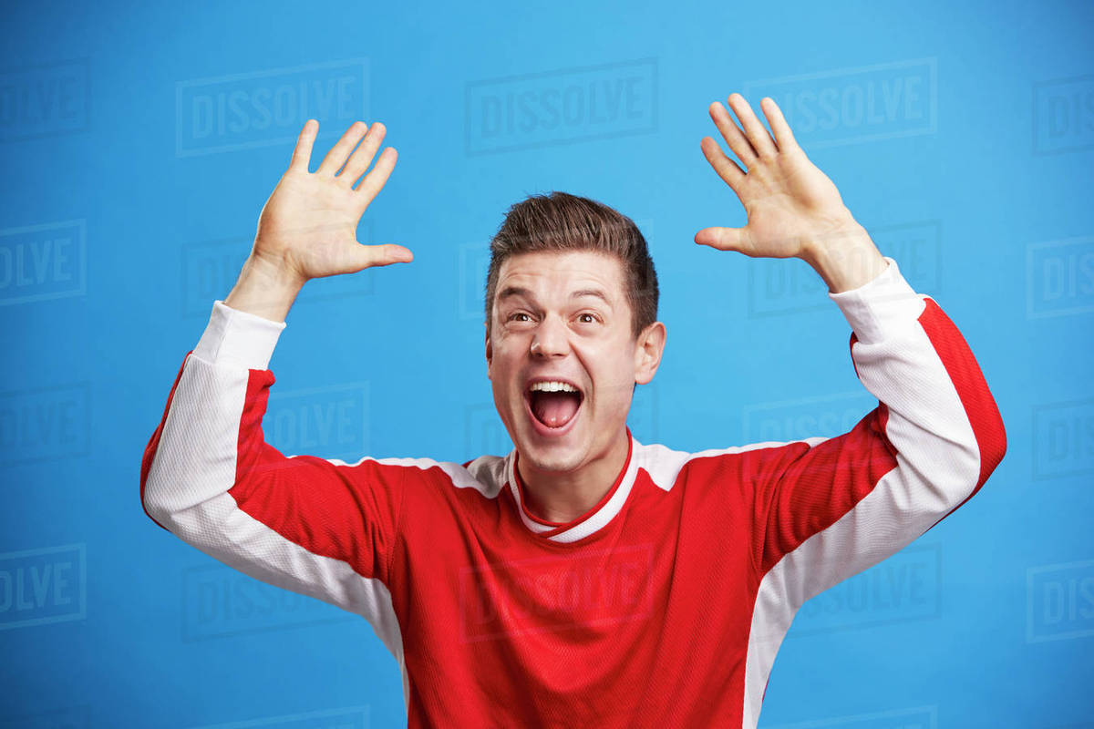 Young white male sports fan celebrating with arms in the air - Royalty ...