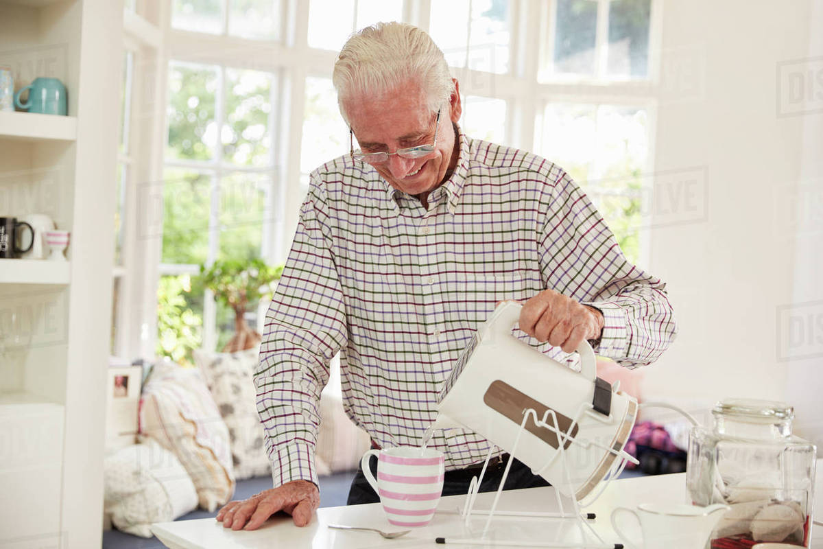 Senior man making cup of tea at home - Royalty-free Stock Photo | Dissolve