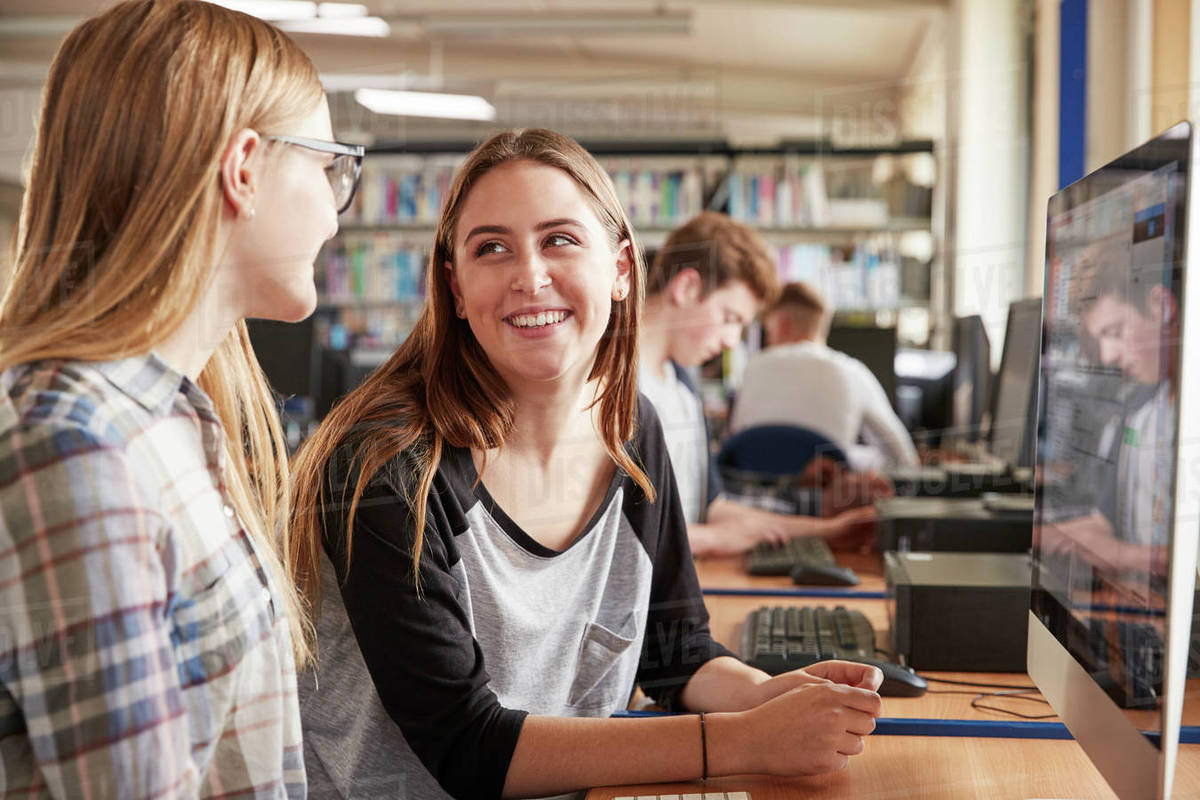Two Female Students Working On Computer In College Library - Royalty ...