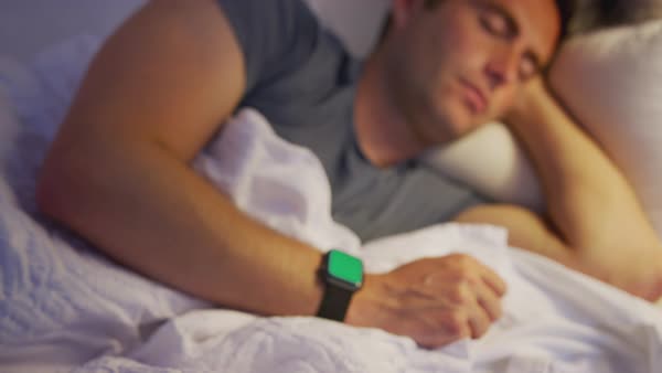 Camera Zooms In On Man Sleeping In Bed Wearing Smart Watch - 4K Royalty ...