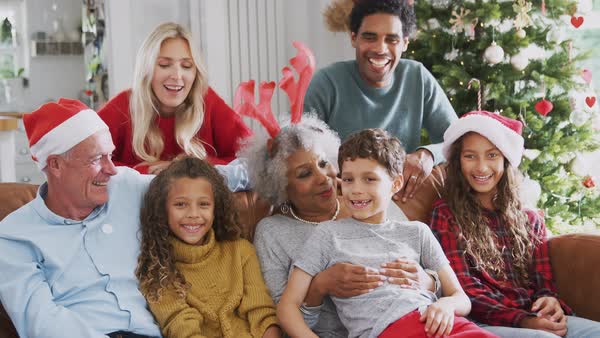 Portrait Of Multi-Generation Family Sitting On Sofa Celebrating ...