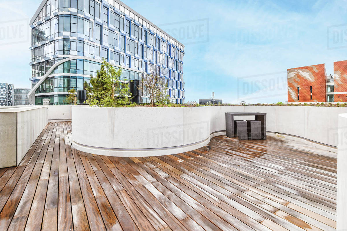 Modern city building with glass mirrored facade seen from terrace with ...