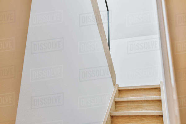 Low angle of white walls and wooden steps of staircase inside of ...