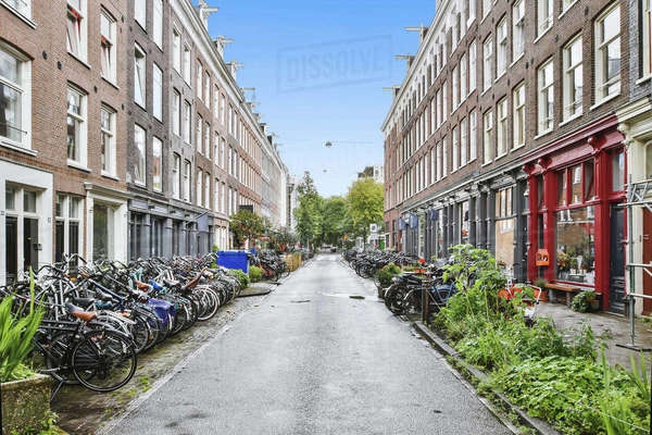 Straight asphalt road between aged brick houses with traditional ...