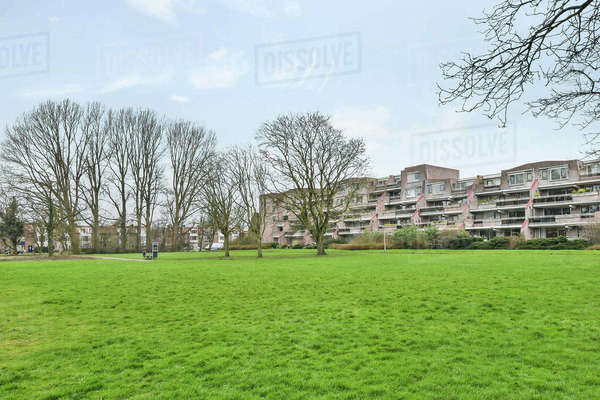Low rise residential building with large green lawn in front and ...