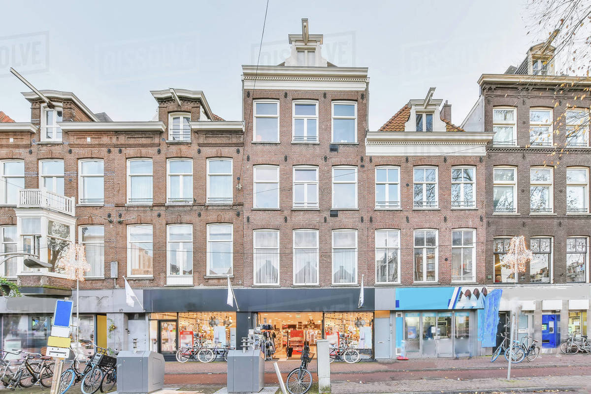 Beautiful four-storey buildings with shops on the ground floor - Stock ...