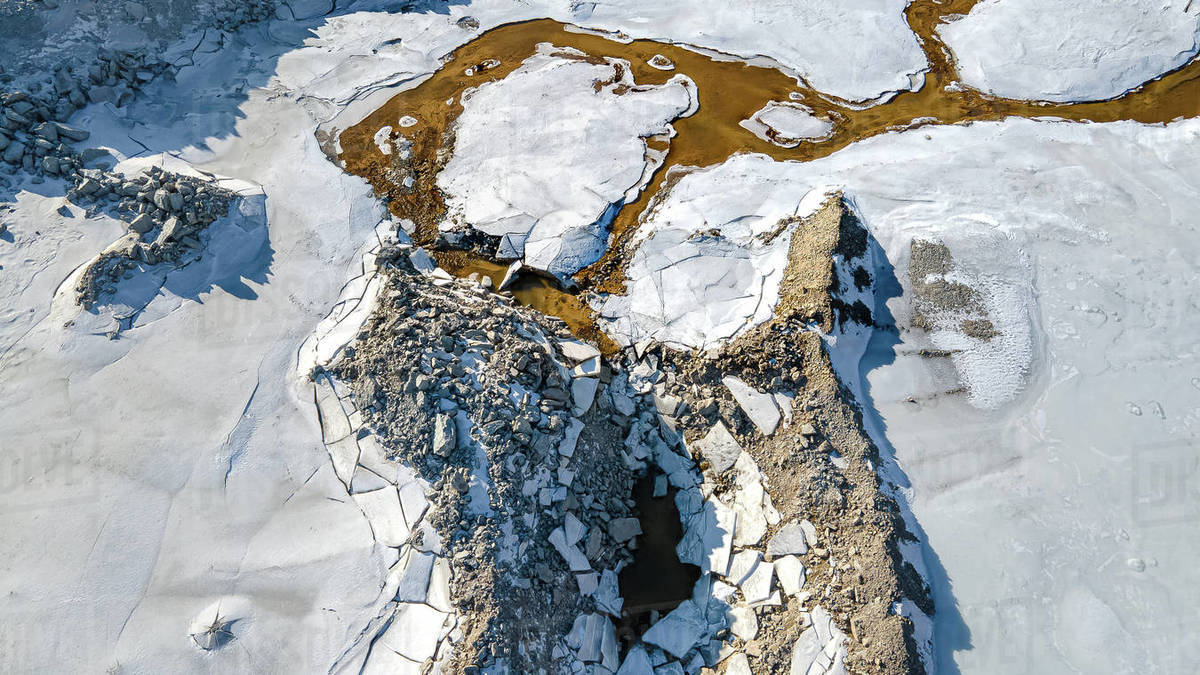 Ice cracking at a quarry creating a small stream. - Stock Photo - Dissolve