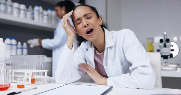 Scientist, tired and woman yawning in laboratory after working on ...