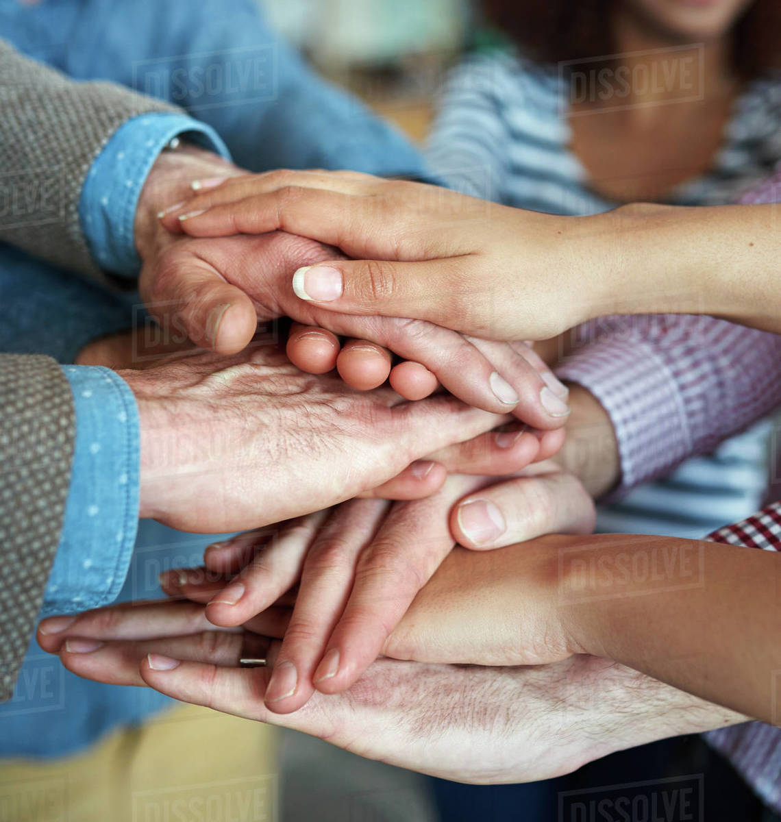 Hands stacked and piled to show team unity, strength or motivation ...