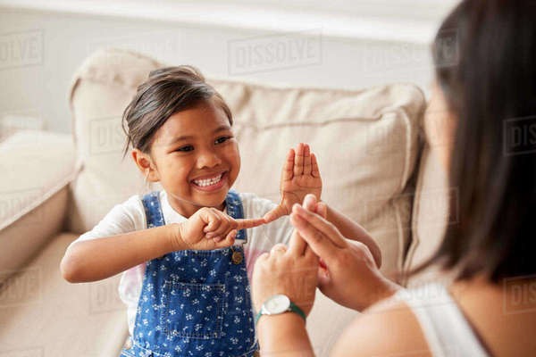 Sign language, learning and girl kid with her mother in the living room ...