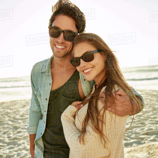 Couple, sea and sunglasses with embrace, happy or care for fashion, eye ...