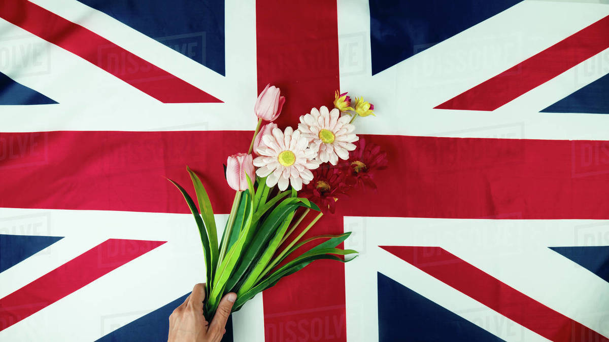 hand holds out bunch of flowers on UK flag. - Royalty-free Stock Photo ...