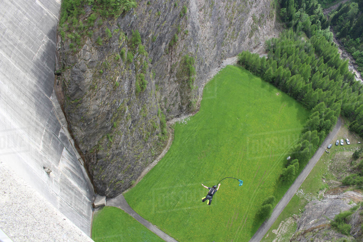 Man base jumping at the Contra dam in Ticino canton, Switzerland ...