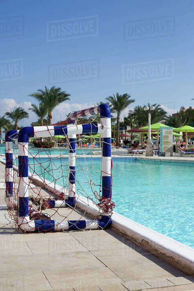 Water polo goal in a clear water pool against the backdrop of a park ...