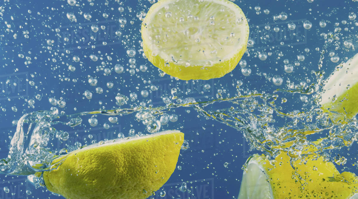 Underwater lemon slice in soda water or lemonade with bubbles. Refreshing soda tonic fizzy ...