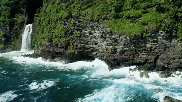 Valley waterfall cascading into Pacific Ocean at Haiku Pauwela on ...