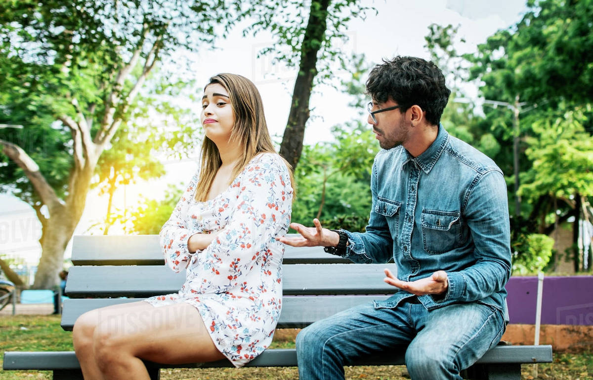 Man arguing with his girlfriend sitting in a park. Upset couple arguing ...