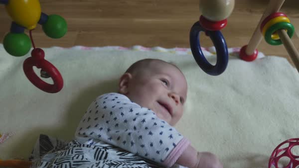 Infant playing with dangling toys on baby gym - 4K Royalty-free Stock ...