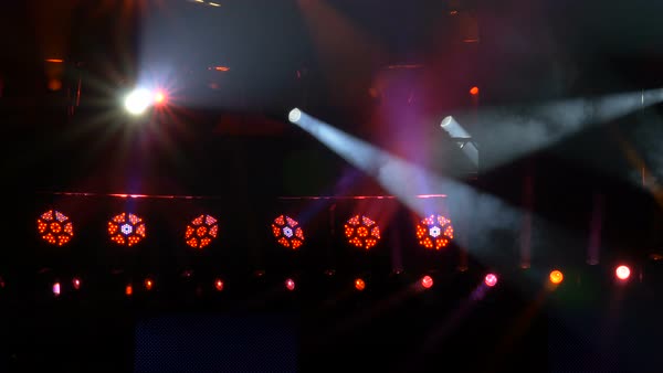 A row of LED stage lights shine directly at the camera. Beam lights ...