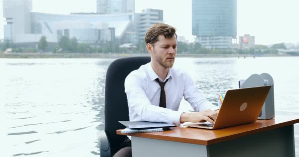 Man sit in water, typing on a laptop, tired from office. Freelancer ...