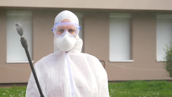 CLOSE UP, PORTRAIT: Female civil protection worker decontaminates the ...