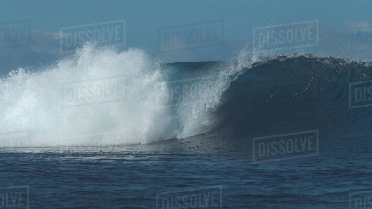 Beautiful sparkling ocean wave crashes wildly and sends blue water ...