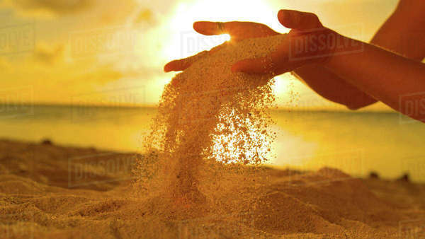 CLOSE UP: Young woman on summer holiday letting coarse sand slip ...