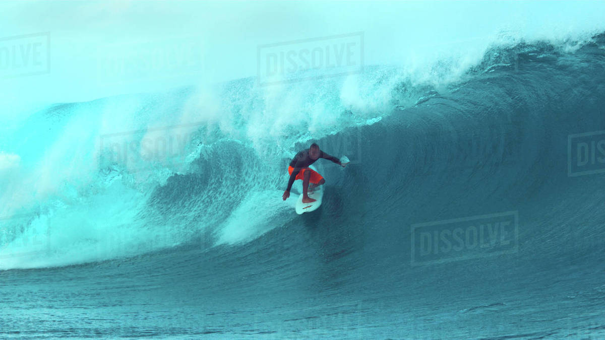 CLOSE UP: Male pro surfboarder rides and carves a giant glassy tropical ...