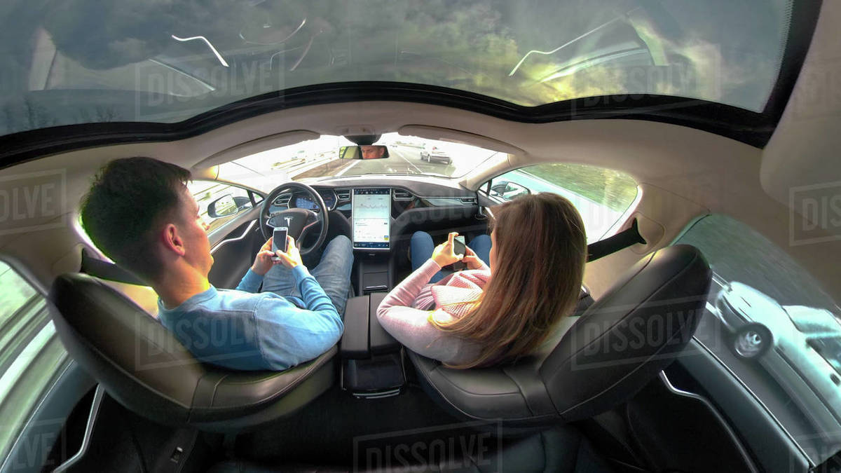 TESLA AUTONOMOUS CAR, March 2018 - CLOSE UP: Careless young couple ...