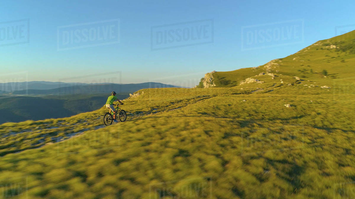 AERIAL: Flying above an active man riding his bicycle down the ...