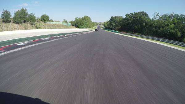Low angle view: race car competing and driving fast on race track lap ...