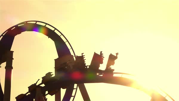 Slow motion close-up: people riding extreme roller coaster attraction ...