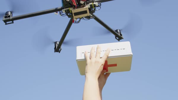 CLOSE UP: UAV aerial drone delivery. Multicopter flying with first aid ...