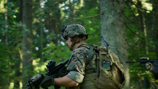Fully equipped soldiers wearing camouflage uniform attacking enemy ...
