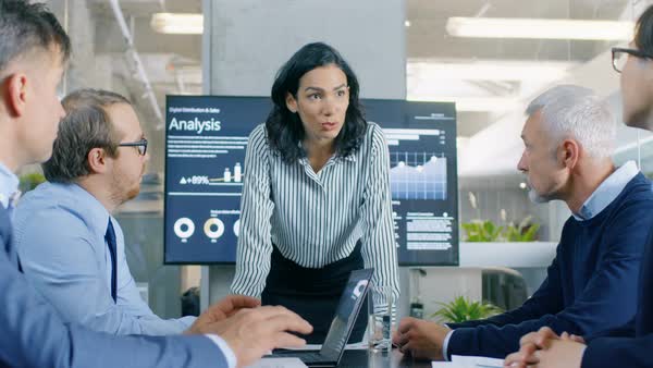 Chief female executive leans on the table and outlines corporate vision ...