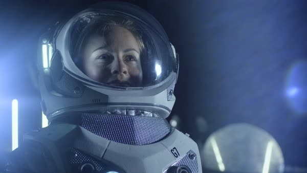 Portrait of female astronaut on the alien planet looking around in ...