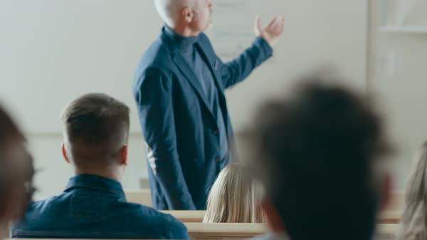 Back view of the students in the lecture hall listening to a prominent ...