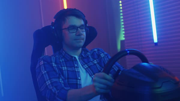 Pro gamer sitting in the racing seat simulator cockpit with steering ...