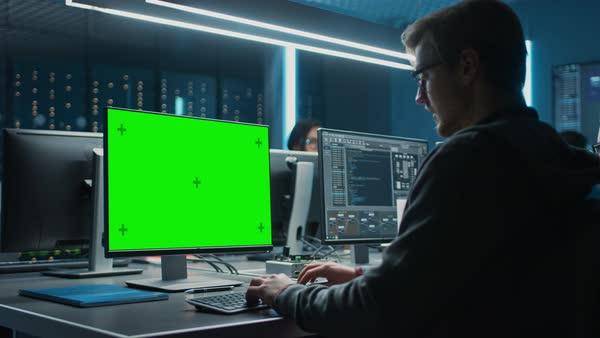 Smart male it programer working on desktop green mock-up screen ...